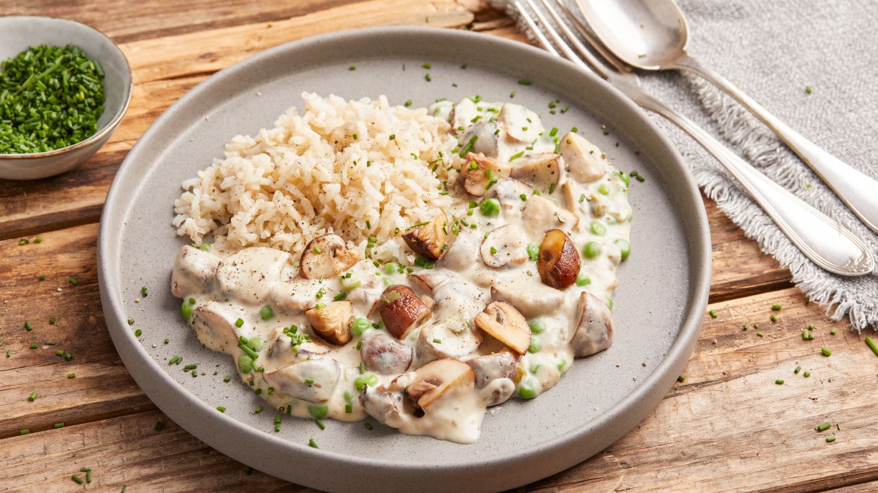Pilze in einer Rahmsauce mit Erbsen und Reis